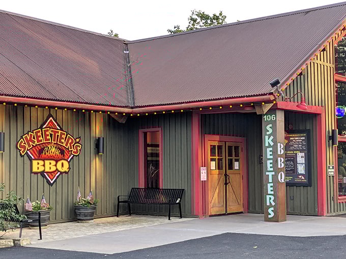 The green cabin-like exterior of Skeeter's BBQ stands like a rustic temple to smoked meat, its red-trimmed windows promising delicious secrets within.
