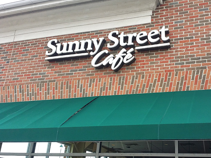 The unassuming brick exterior of Sunny Street Café, where culinary magic happens behind those modest green awnings. Breakfast nirvana awaits!