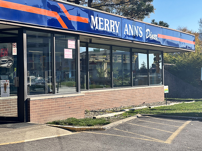 The blue and orange beacon of Merry Ann's Diner glows like a midnight oasis, promising salvation in the form of perfectly crispy hash browns and endless coffee.