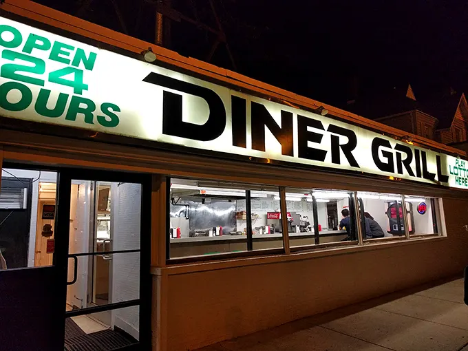 The neon "OPEN 24 HOURS" sign glows like a lighthouse for hungry night owls, promising salvation in the form of perfectly griddled comfort food.