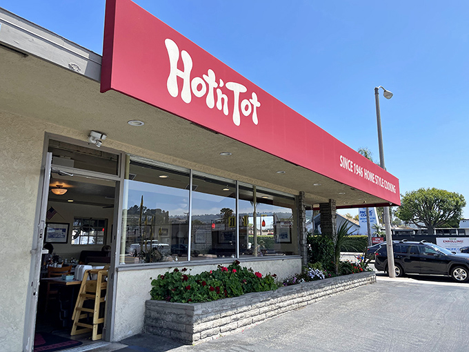 The iconic red signage of Hot 'n Tot stands as a beacon of culinary consistency on Pacific Coast Highway, promising homestyle comfort since 1946.