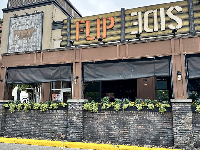 The rustic-industrial facade of Flip Side beckons hungry travelers with its bold signage and inviting brick patio—a carnivore's lighthouse in Easton's retail sea.