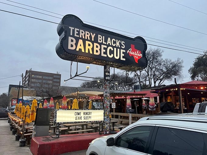 The neon BBQ sign glows like a smoky beacon of hope for hungry travelers. Terry Black's industrial-chic exterior promises no frills—just exceptional barbecue worth the journey.