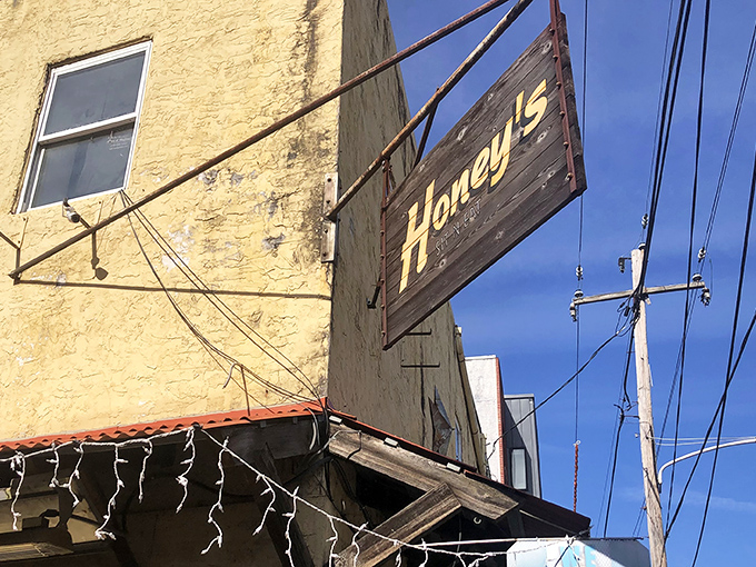 That weathered wooden sign against the yellow building isn't just decoration—it's a beacon for breakfast pilgrims seeking Philadelphia's comfort food promised land.