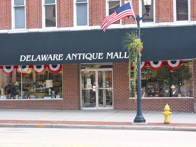 The iconic burgundy awning of Delaware Antique Mall beckons treasure hunters into this historic brick building, where the past awaits rediscovery.