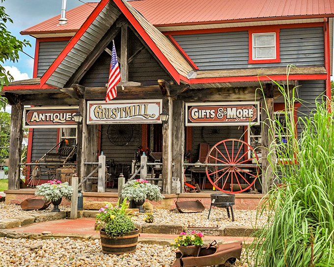 The weathered facade of Grist Mill Antiques beckons like an old friend, complete with wagon wheel and seasonal decor that whispers, "Come in, the past is waiting."