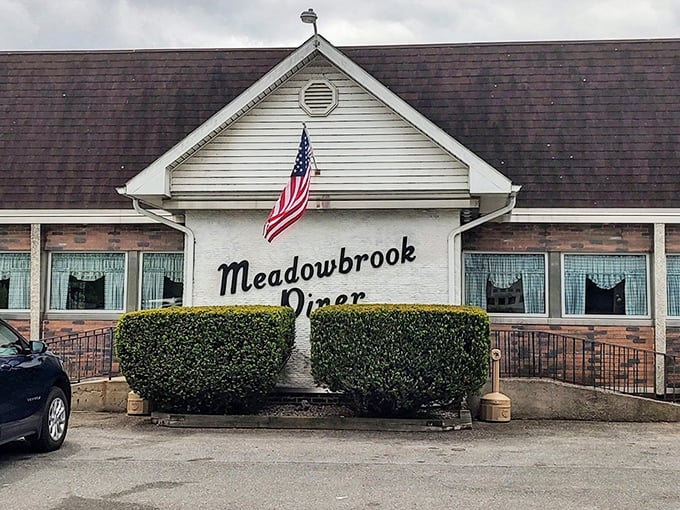 The classic American flag above Meadowbrook Diner isn't just decoration—it's a promise that inside awaits the kind of breakfast that made this country great.