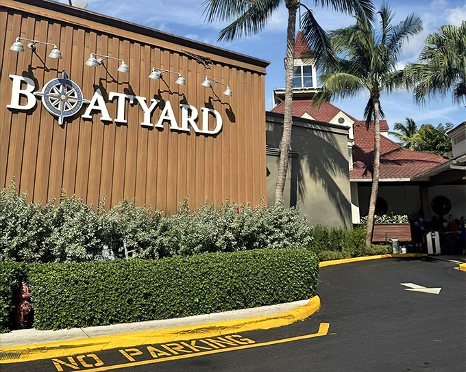 The nautical-inspired exterior of Boatyard welcomes seafood lovers with its compass logo and meticulously maintained hedges—Florida dining with maritime flair.