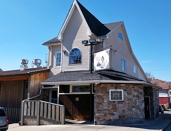 The storybook-meets-stonework exterior of Jack & Georges stands like a culinary lighthouse, beckoning hungry travelers with its distinctive peaked roof and rustic charm.