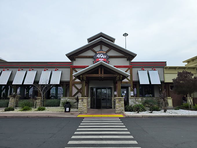 The 49er Diner's rustic exterior welcomes hungry travelers like a gold rush promise – comfort food treasures await just beyond those wooden beams and stone pillars.