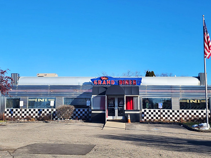 The classic stainless steel exterior gleams in the Michigan sunshine, promising comfort food treasures within. That neon sign? Pure roadside Americana.