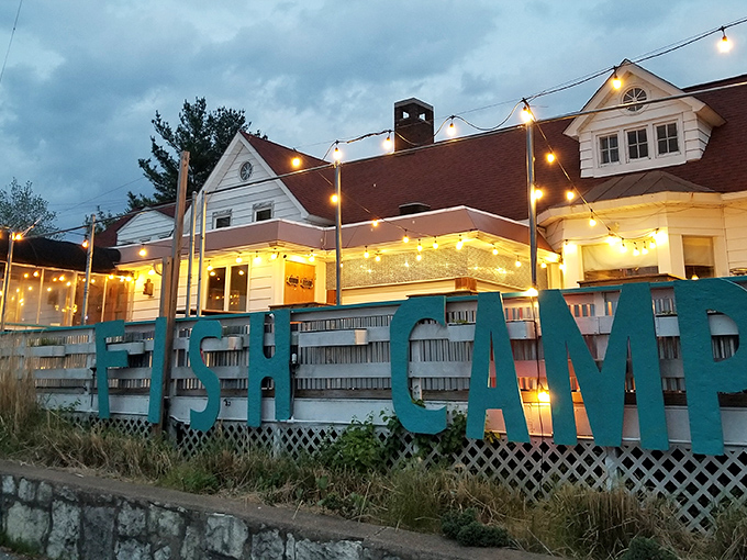 The bold white "FISH CAMP" sign against the white building is like a lighthouse for hungry souls—guiding seafood pilgrims to their delicious destination.