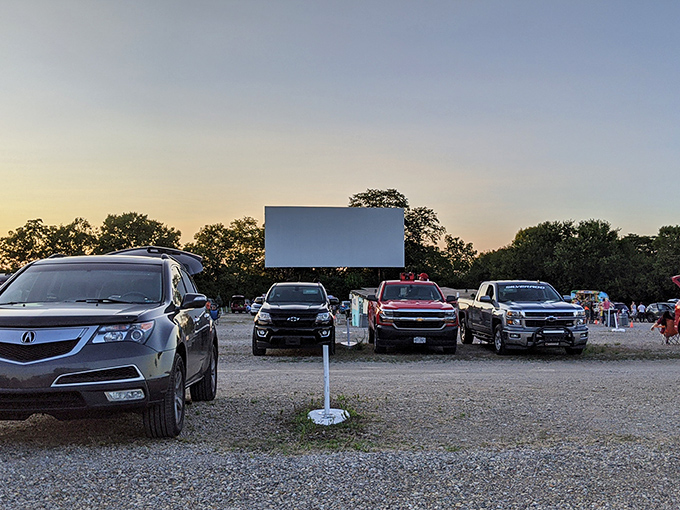 Twilight transforms this gravel lot into a communal living room, where strangers become neighbors under the glow of cinema magic. 