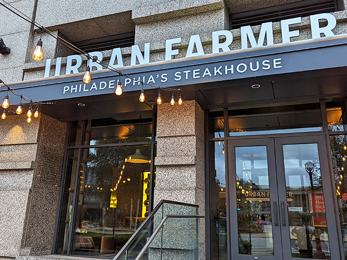 The modern façade beckons with its clean lines and warm string lights—Philadelphia's steakhouse revolution hiding in plain sight.