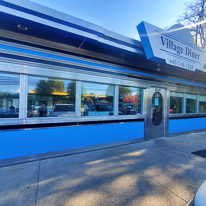 The classic blue-trimmed exterior of Village Diner stands like a time capsule of Americana, promising honest food without pretension.
