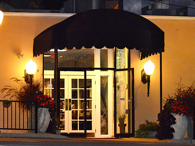 The entrance to Tavern on the Hill beckons with elegant simplicity, flanked by seasonal blooms and classic sconce lighting—like a culinary speakeasy hiding in plain sight.