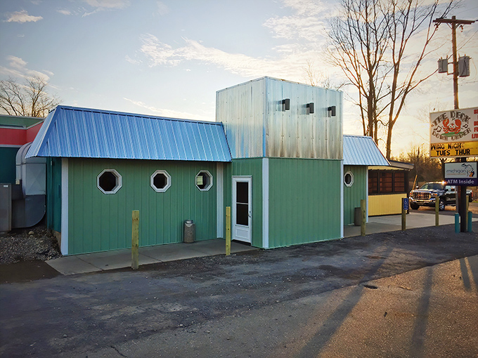 The mint-green exterior with porthole windows and blue metal roof stands like a cheerful seafood oasis along the Michigan roadside.