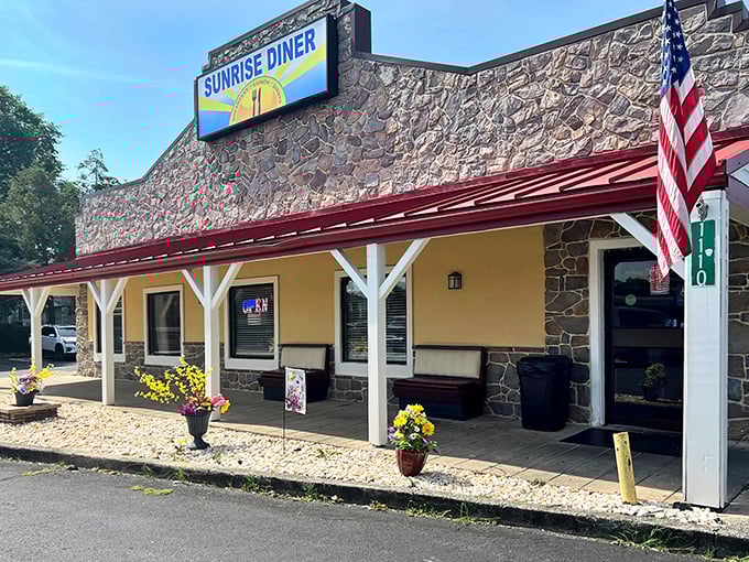 Stone walls and a welcoming porch make Sunrise Diner a roadside beacon for hungry travelers. The American flag flutters proudly, promising patriotic portions inside.