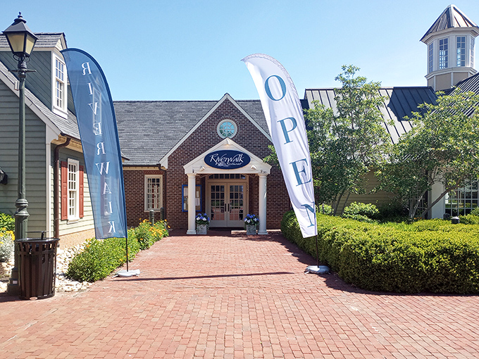 The welcoming brick façade of Riverwalk Restaurant stands like a culinary lighthouse, beckoning hungry travelers with its classic colonial charm and blue signage.