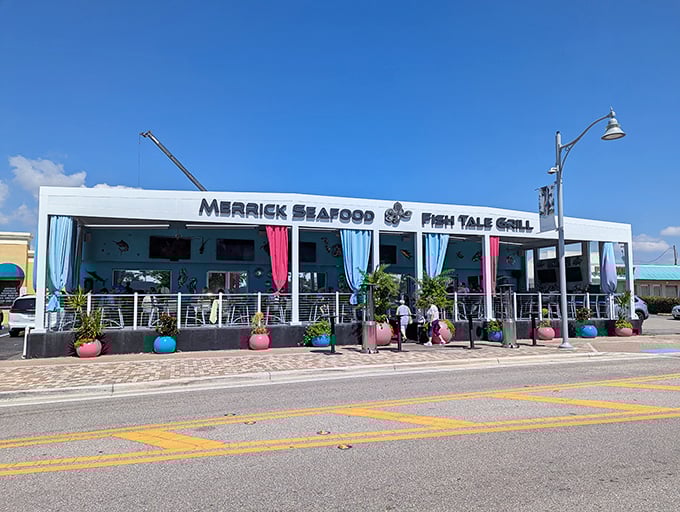 The neon-lit exterior of Fish Tale Grill beckons like a lighthouse for hungry seafood lovers. Purple lighting transforms this Cape Coral hotspot into an underwater fantasy after dark.