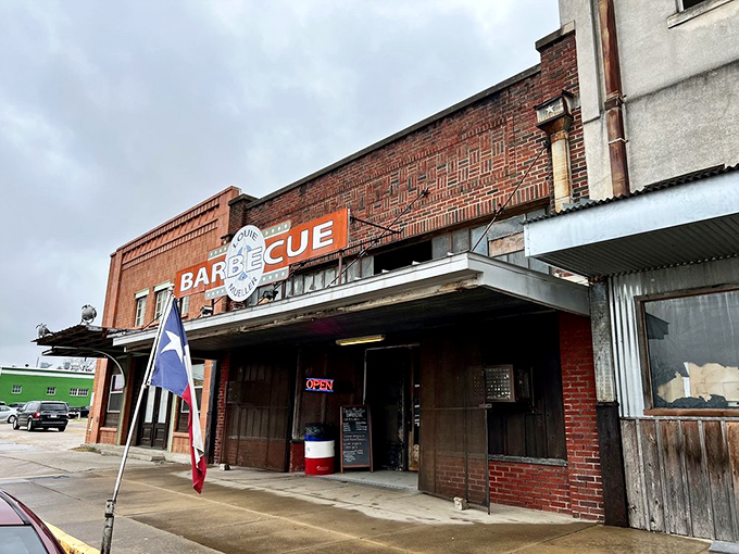 The brick façade and iconic red sign of Louie Mueller Barbecue stand as a beacon of hope for hungry travelers. Texas barbecue pilgrimage starts here.