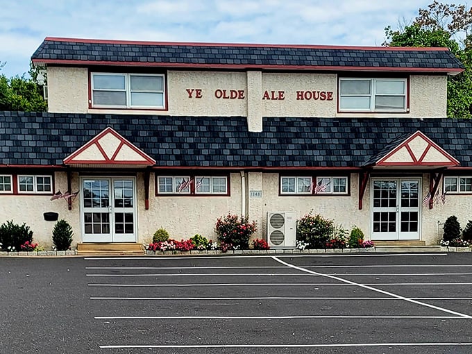 The unassuming exterior of Ye Olde Ale House stands like a culinary speakeasy—no flash, all substance. American flags flutter gently, promising patriotism with your pot roast.