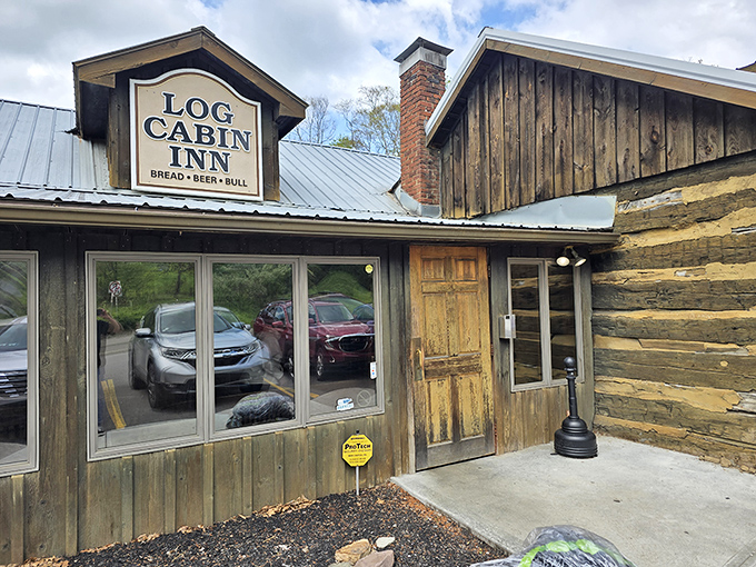 The Log Cabin Inn's weathered wooden exterior isn't just rustic charm—it's a promise of culinary treasures hiding behind that unassuming frontier facade.