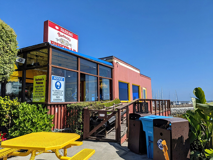The iconic red exterior of Barbara's Fishtrap stands like a colorful sentinel against the Half Moon Bay coastline, promising seafood treasures within.