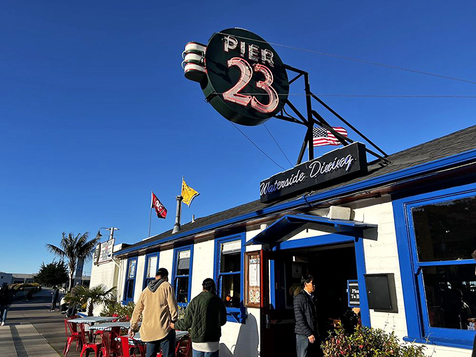 The iconic blue-trimmed exterior of Pier 23 Cafe stands like a maritime postcard come to life, beckoning hungry travelers with its classic San Francisco waterfront charm.
