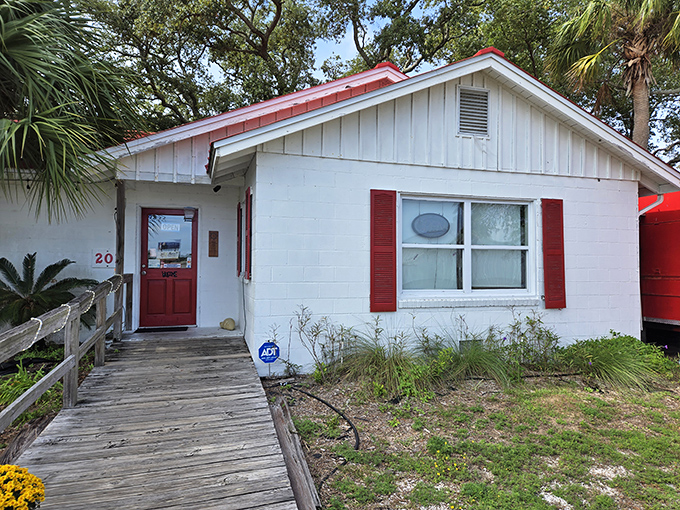 The unassuming white cottage with its weathered red roof and hand-painted sign promises what Florida seafood should be: fresh, unpretentious, and absolutely worth finding.
