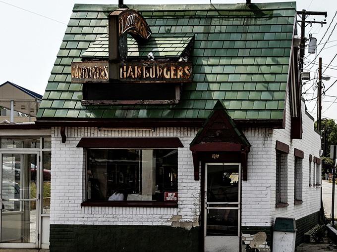 The iconic green-shingled roof and weathered "DONUTS HAMBURGERS" sign announce this Laurel institution without fanfare—architectural honesty at its most delicious.