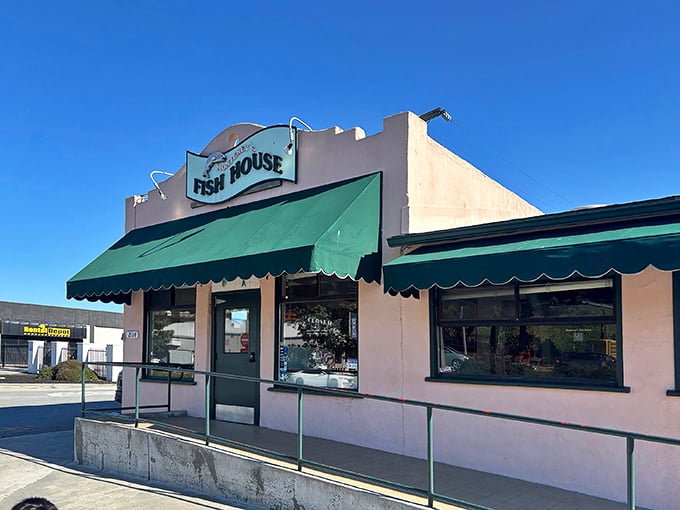 The unassuming pink exterior with green awnings might fool you, but locals know—culinary treasures often hide in plain sight.