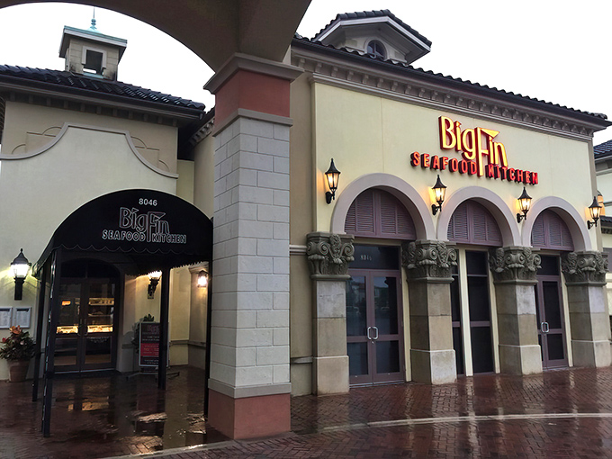 Mediterranean elegance meets Florida flair at Big Fin's inviting entrance. The warm lighting and arched doorways promise seafood adventures beyond the ordinary.