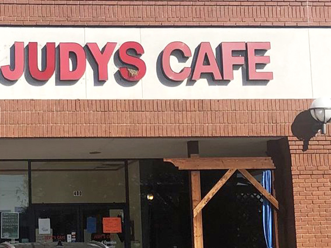 The red lettering of Judy's Cafe against brick promises what every great Texas breakfast spot should: no pretension, just honest-to-goodness satisfaction waiting inside.