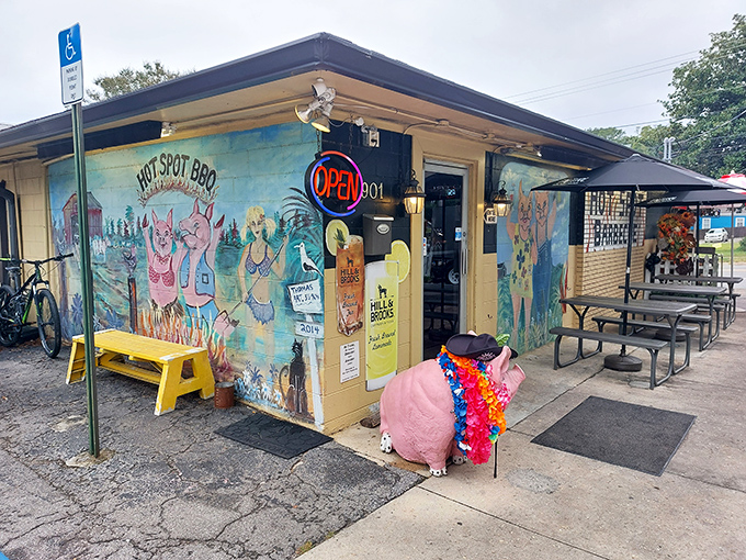The unassuming yellow exterior of Hot Spot Barbecue, where those red umbrellas aren't just for show—they're beacons guiding hungry souls to barbecue nirvana.