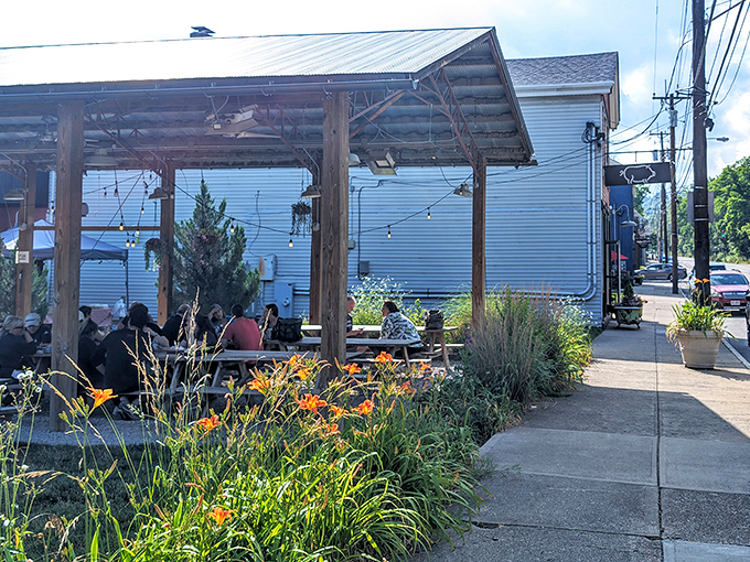 The outdoor patio at Eli's BBQ is where summer dreams come true—string lights, wooden beams, and wildflowers creating the perfect backdrop for smoky indulgence. 