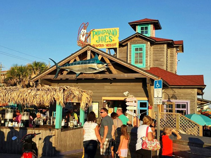 The weathered wooden exterior of Pompano Joe's, complete with its iconic watchtower and mounted marlin, promises seafood authenticity before you even step inside.