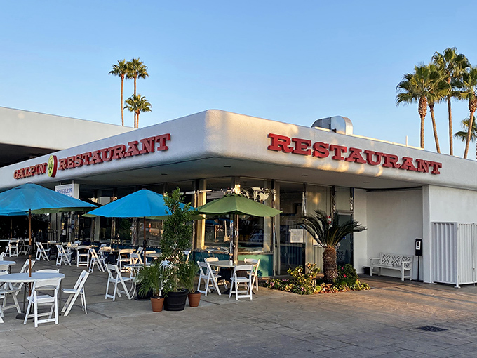 Mid-century modern meets palm tree paradise at this North Hills gem. The outdoor patio beckons with blue umbrellas and California sunshine.