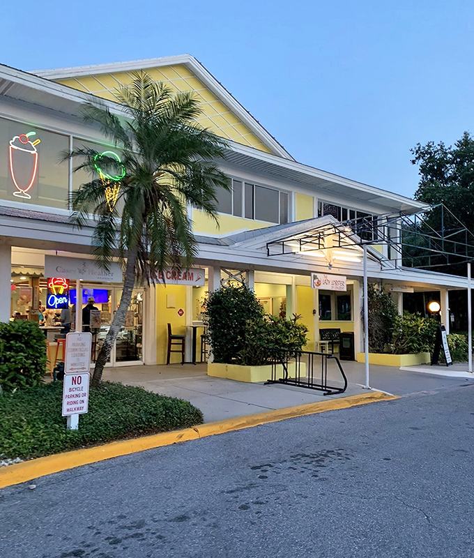 The cheerful yellow exterior of Lazy Lobster beckons like Florida sunshine in building form, promising seafood treasures within its casual, palm-fringed setting.