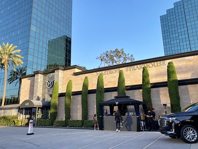The stone façade and perfectly manicured cypress trees aren't just for show—they're your first clue that dinner tonight will be several notches above a drive-thru experience.