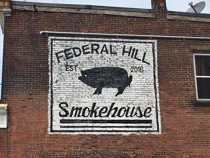 The unassuming brick corner that houses barbecue greatness. That painted pig logo isn't just decoration—it's a beacon calling hungry souls home.