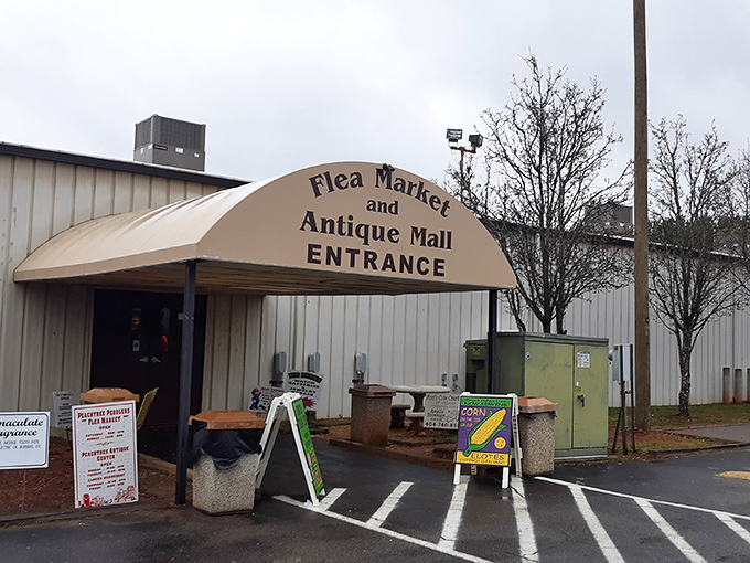 The unassuming entrance to Peachtree Peddler's – where treasure hunting begins beneath a simple awning that hides a world of wonders inside.