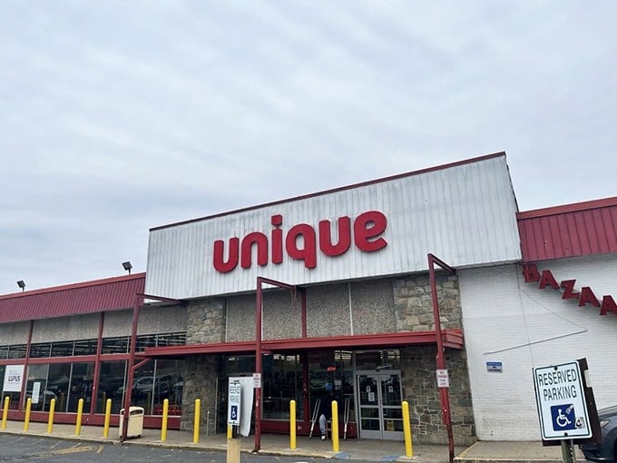 The iconic red "unique" sign beckons bargain hunters like a retail lighthouse, promising treasures within those unassuming walls.