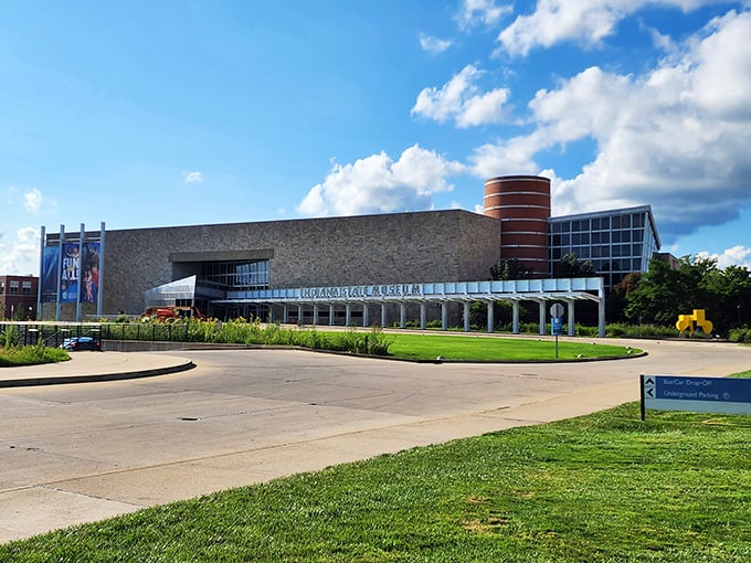 The limestone façade of the Indiana State Museum stands proudly against a blue sky, its modern design blending seamlessly with Indiana's geological heritage.