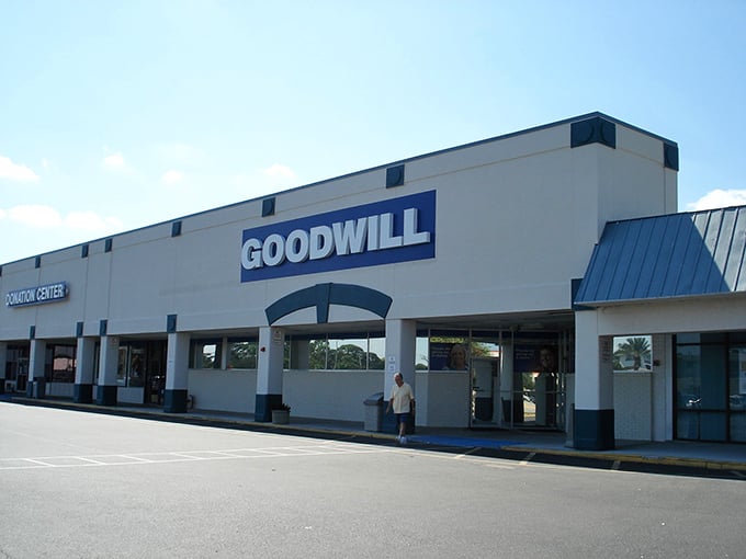 The blue Goodwill sign beckons like a treasure map X-marking-the-spot, promising adventures in secondhand shopping under Florida's ever-present azure skies.