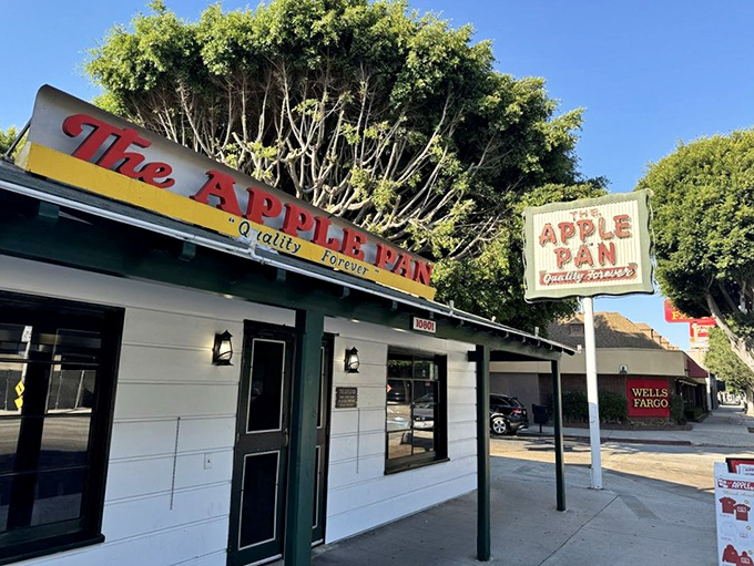 The unassuming white exterior of The Apple Pan stands like a time capsule on Pico Boulevard, its vintage sign promising "Quality Forever" – a bold claim they've been backing up since 1947.