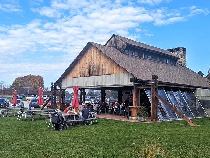 The rustic barn exterior of Sarah's Vineyard welcomes visitors with its weathered wood charm and inviting outdoor seating—Napa Valley spirit with heartland hospitality.