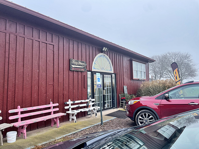 The rustic red exterior of Big Dan's BBQ belies the smoky treasures within. Those pink picnic benches? Nature's way of saying "sit here after your meat sweats begin."