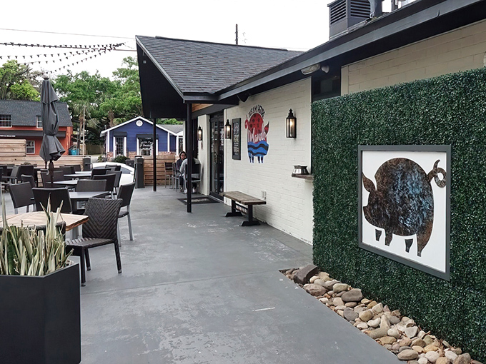 The inviting patio at Pig Floyd's welcomes barbecue pilgrims with playful pig artwork and comfortable outdoor seating—a carnivore's sanctuary in Orlando's Mills 50 district.