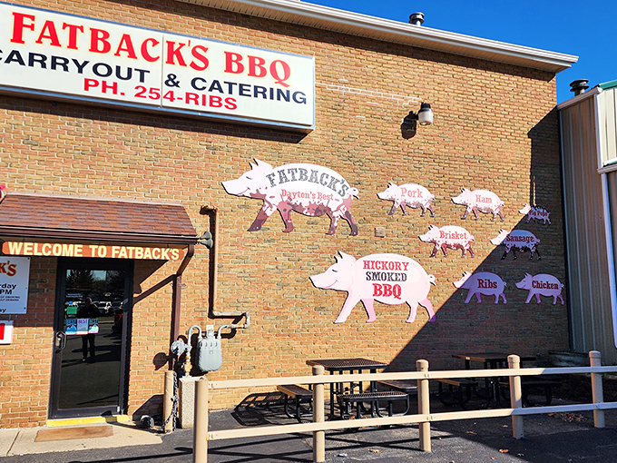 The iconic brick exterior of Fatback's BBQ, where those pig cutouts aren't just decoration—they're a roadmap to smoky paradise.